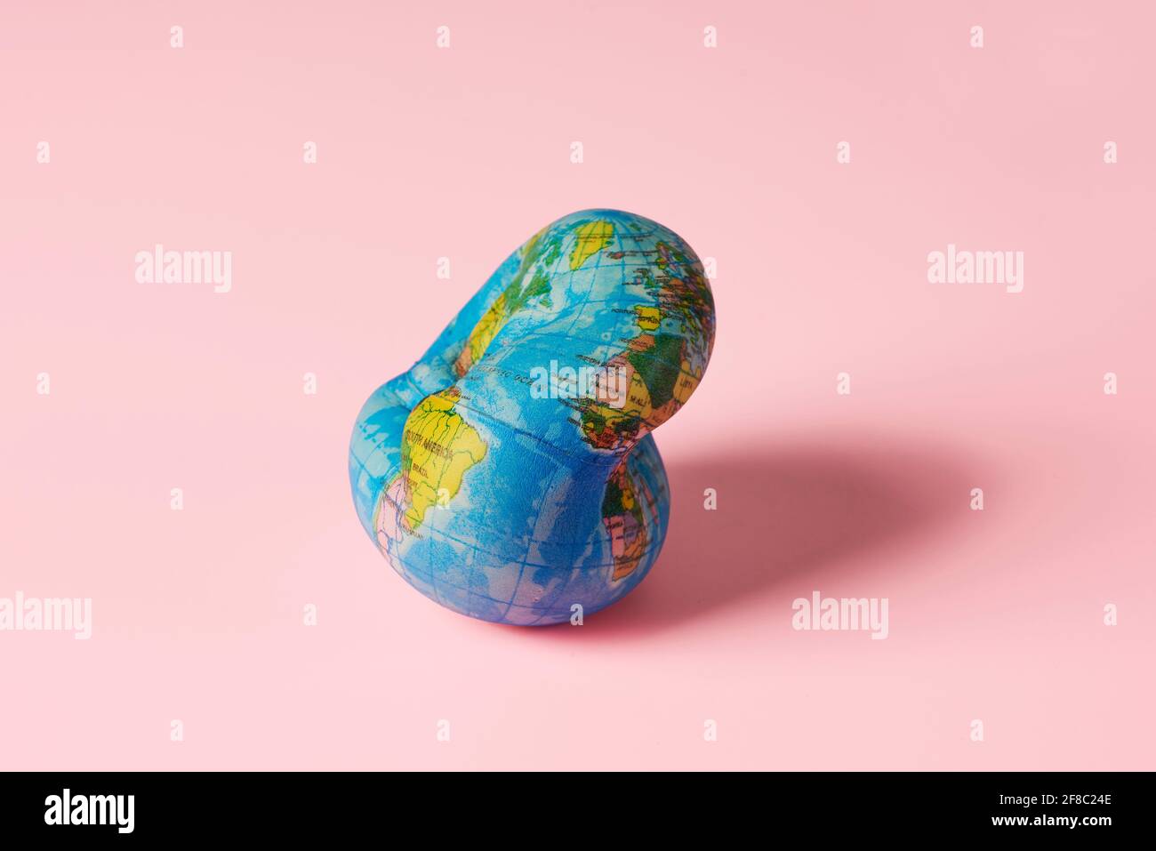a warped soft earth globe on a pink background with some blank space ...