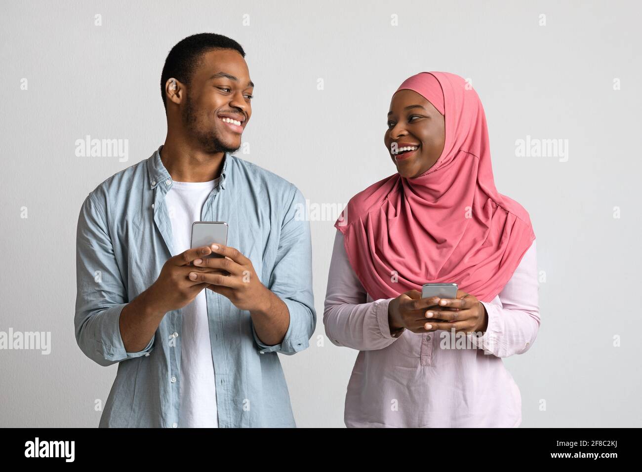 Happy muslim man and woman using mobile phones Stock Photo - Alamy