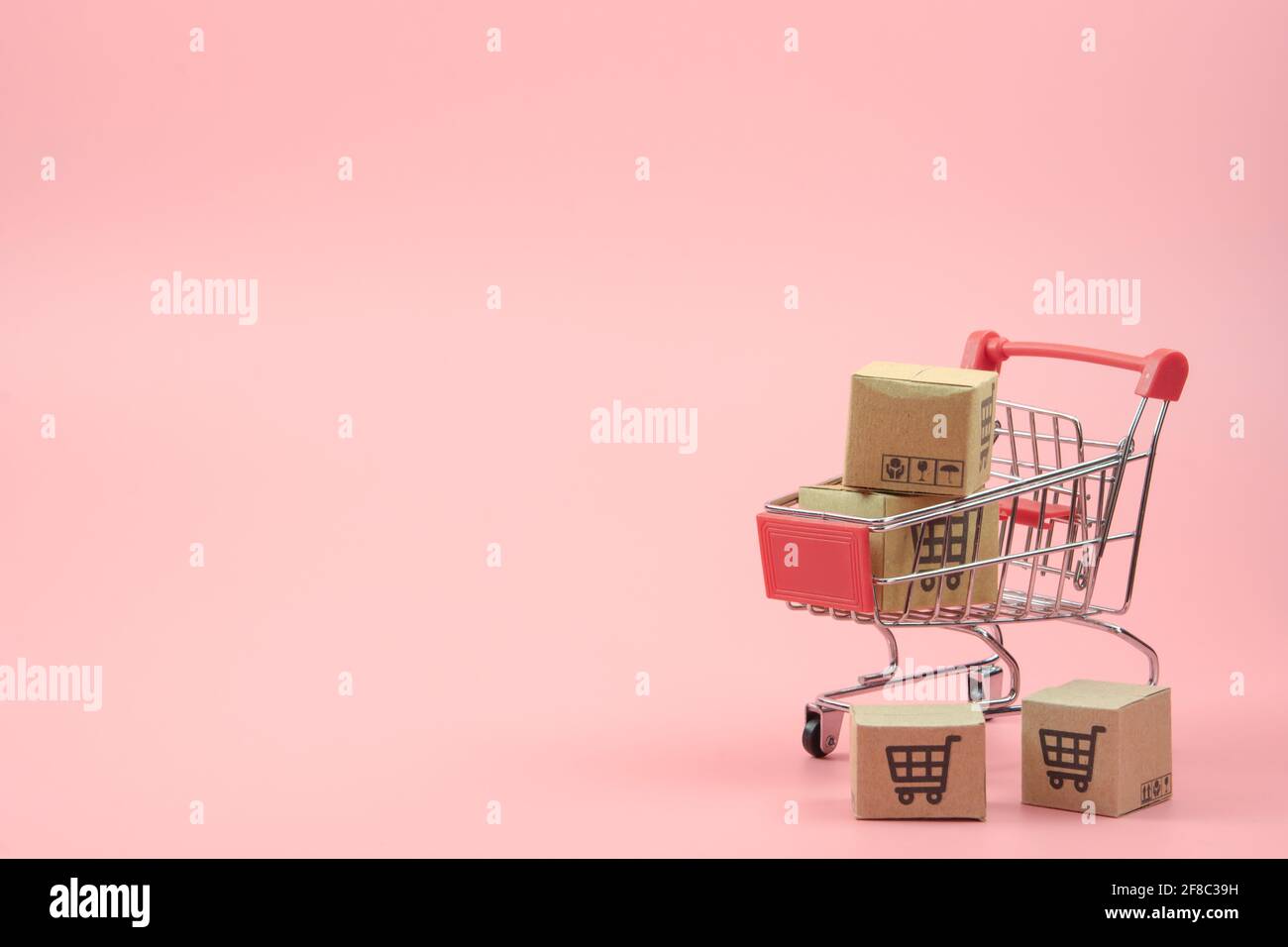 Shopping concept - Cartons or Paper boxes in red shopping cart on pink ...