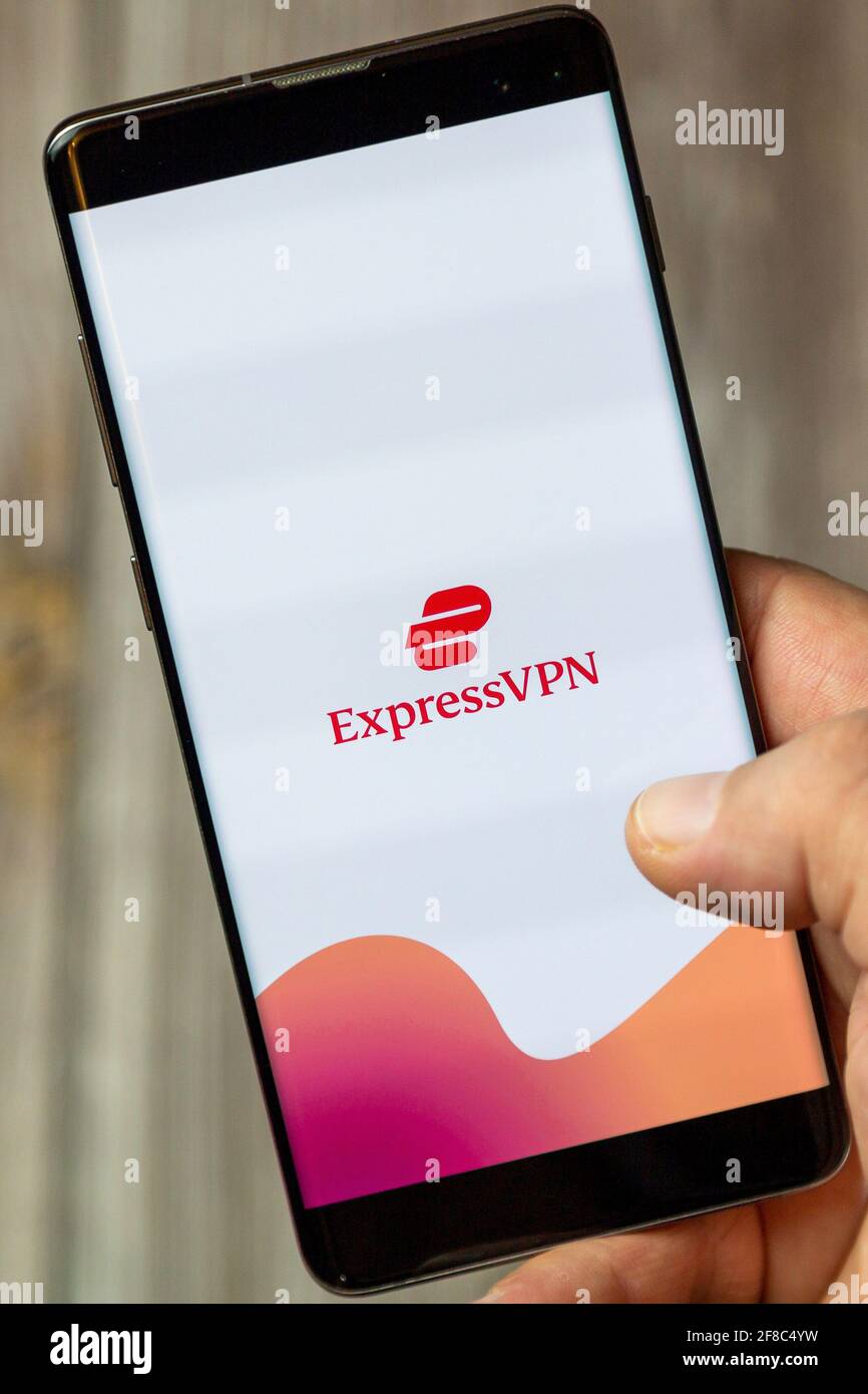 A mobile phone or cell phone being held by a hand with the Express VPN ...