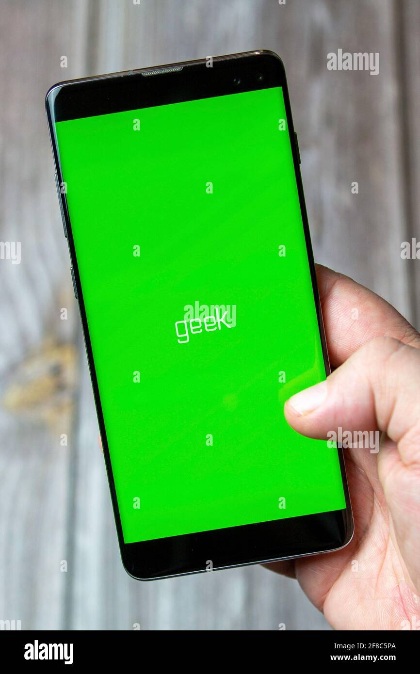A Mobile phone or cell phone being held in a hand with the Geek app ...