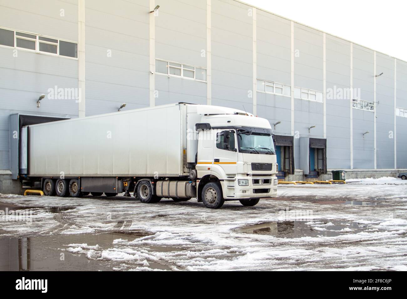 Truck while loading in a big distribution warehouse with gates for for ...