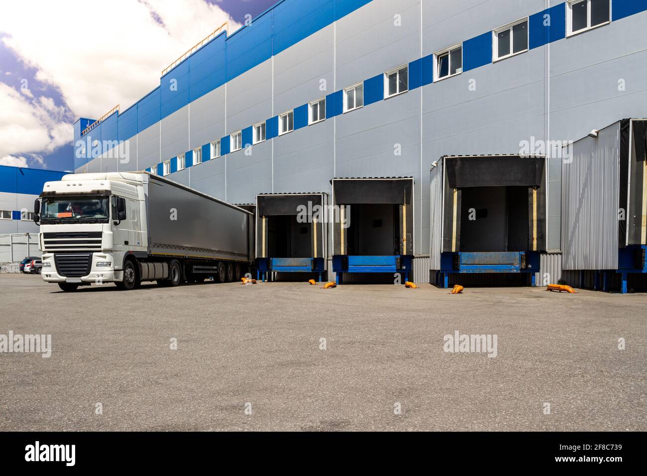 Truck while loading in a big distribution warehouse with gates for for ...