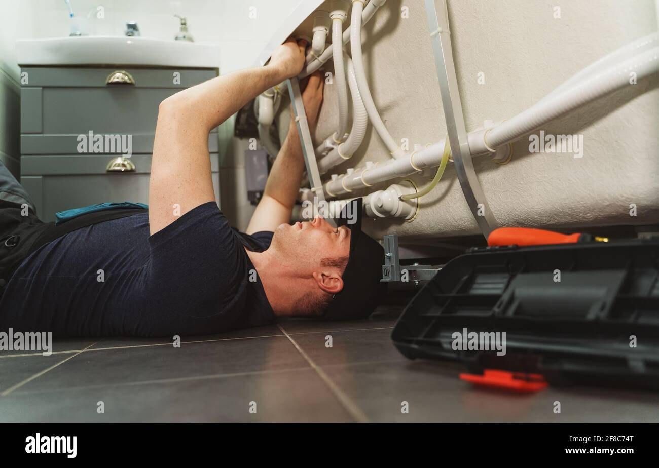 Man installing pipe system of bathtub with hydromassage Stock Photo - Alamy