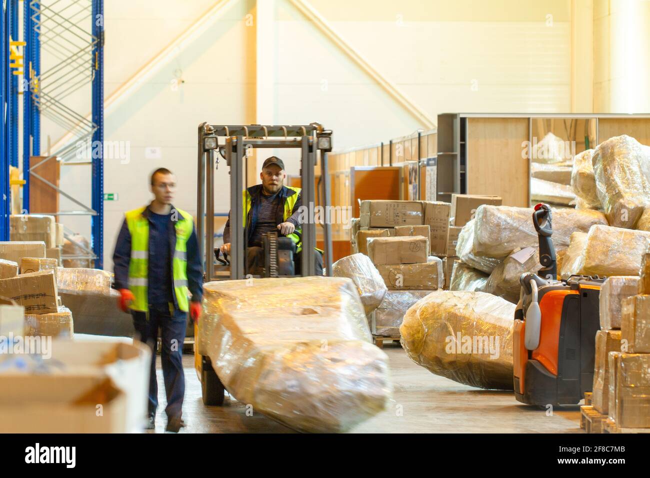 MOSCOW, RUSSIA - MARCH 18, 2021 Warehouse worker driving a forklift ...
