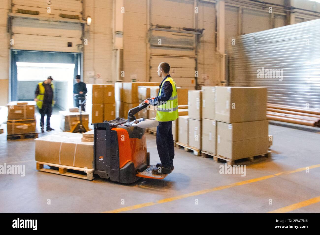 MOSCOW, RUSSIA - MARCH 18, 2021 Warehouse worker driving a forklift ...