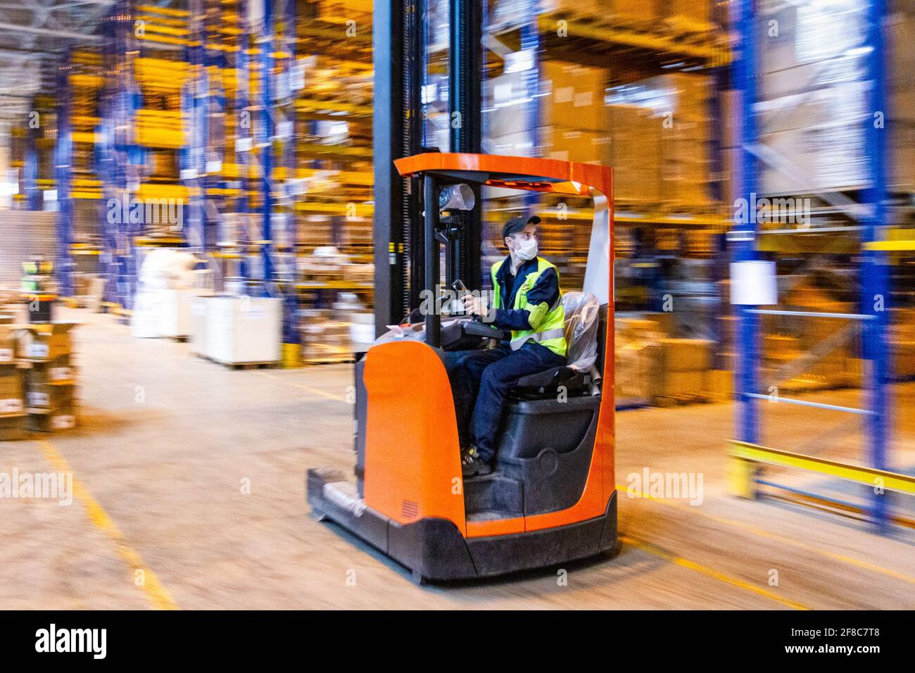 MOSCOW, RUSSIA - MARCH 18, 2021 Warehouse worker driving a forklift ...