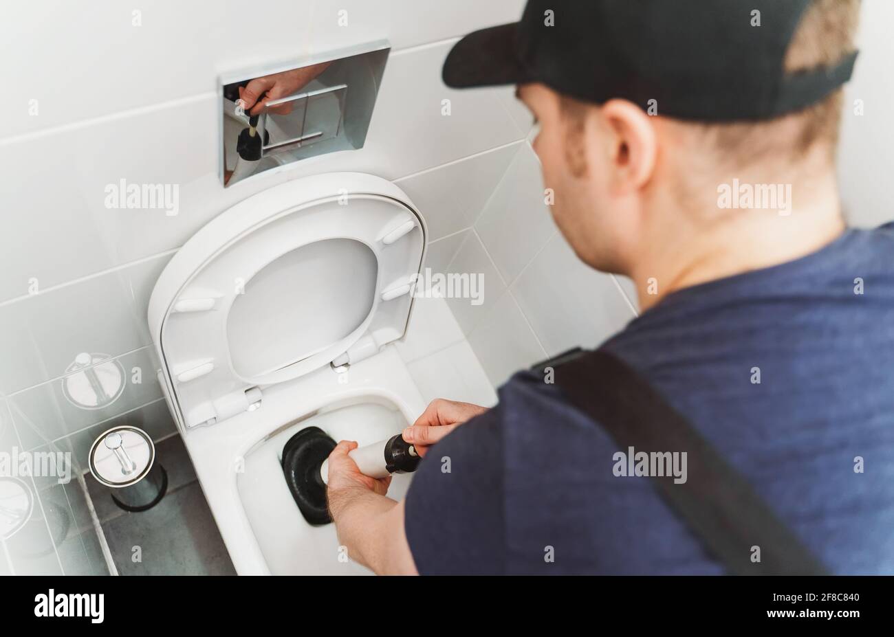 Plumber unclogging toilet with professional force pump cleaner Stock ...