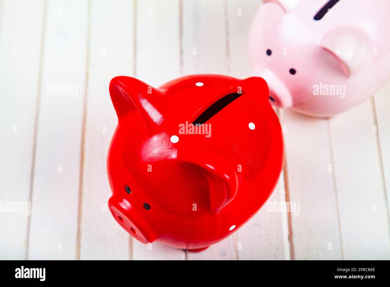 Two pigs piggy banks on a white wooden background. Accumulation of ...