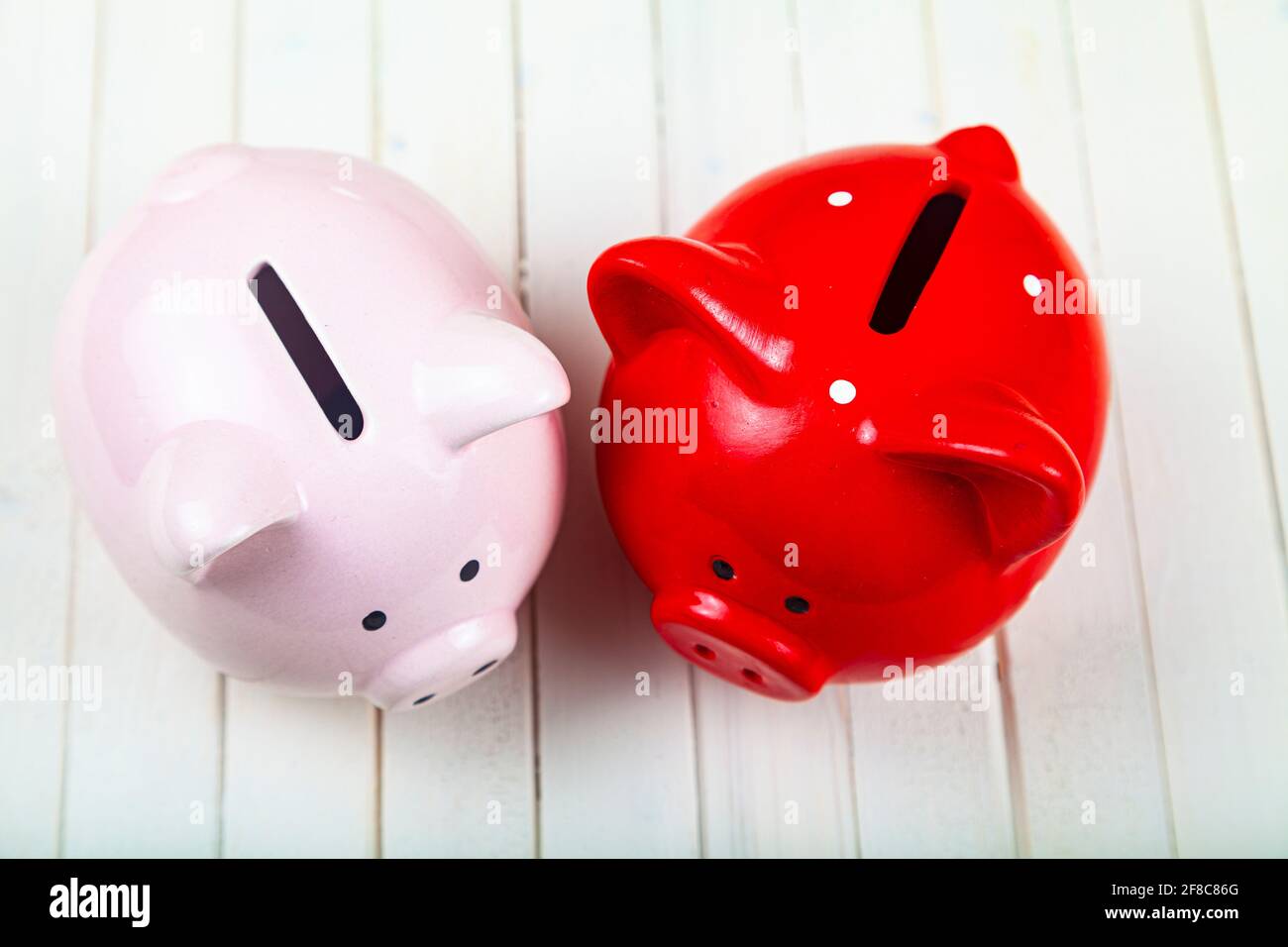Two pigs piggy banks on a white wooden background, top view ...