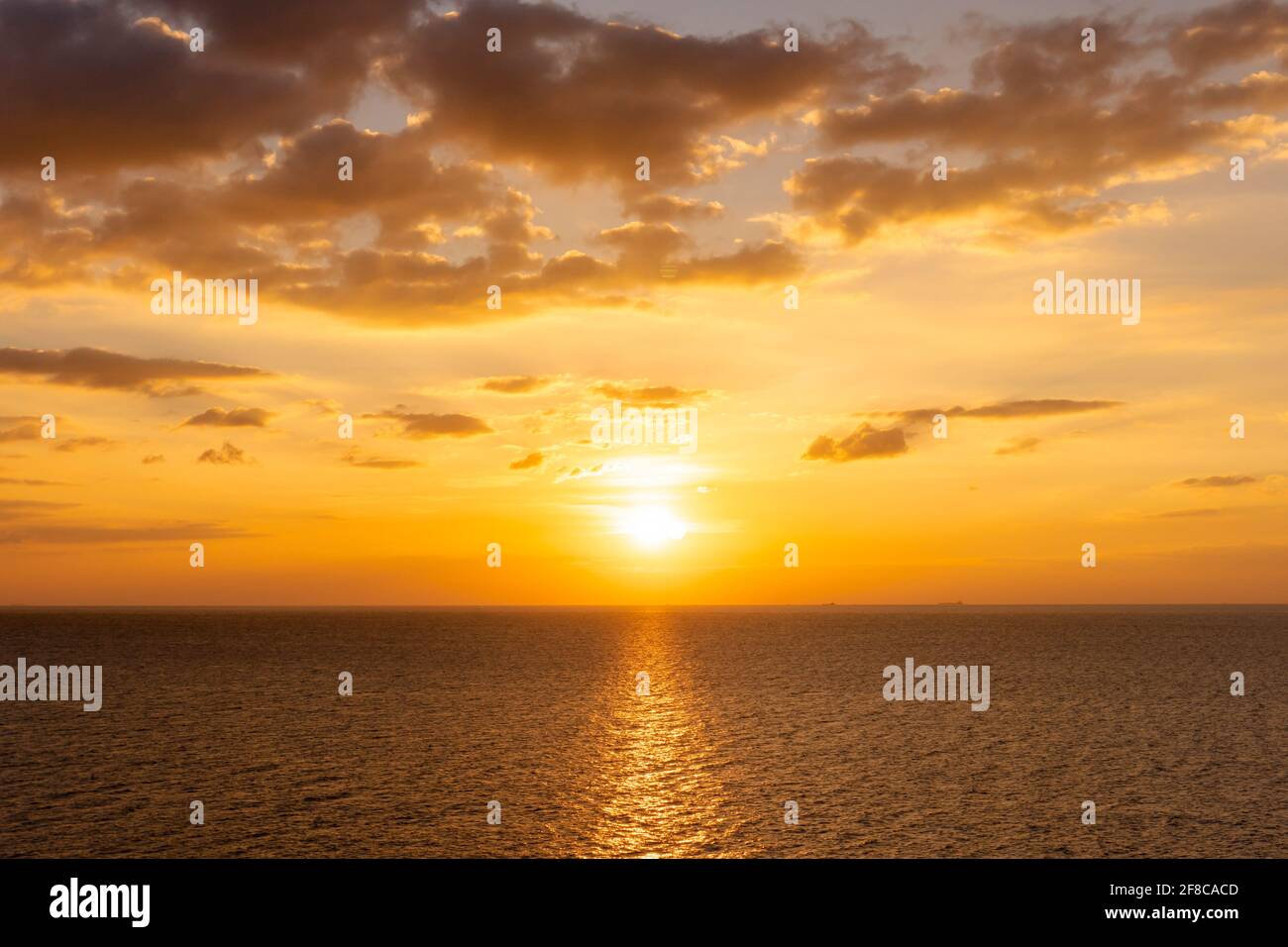 Sunset reflection ocean. beautiful sunset behind the clouds and blue ...