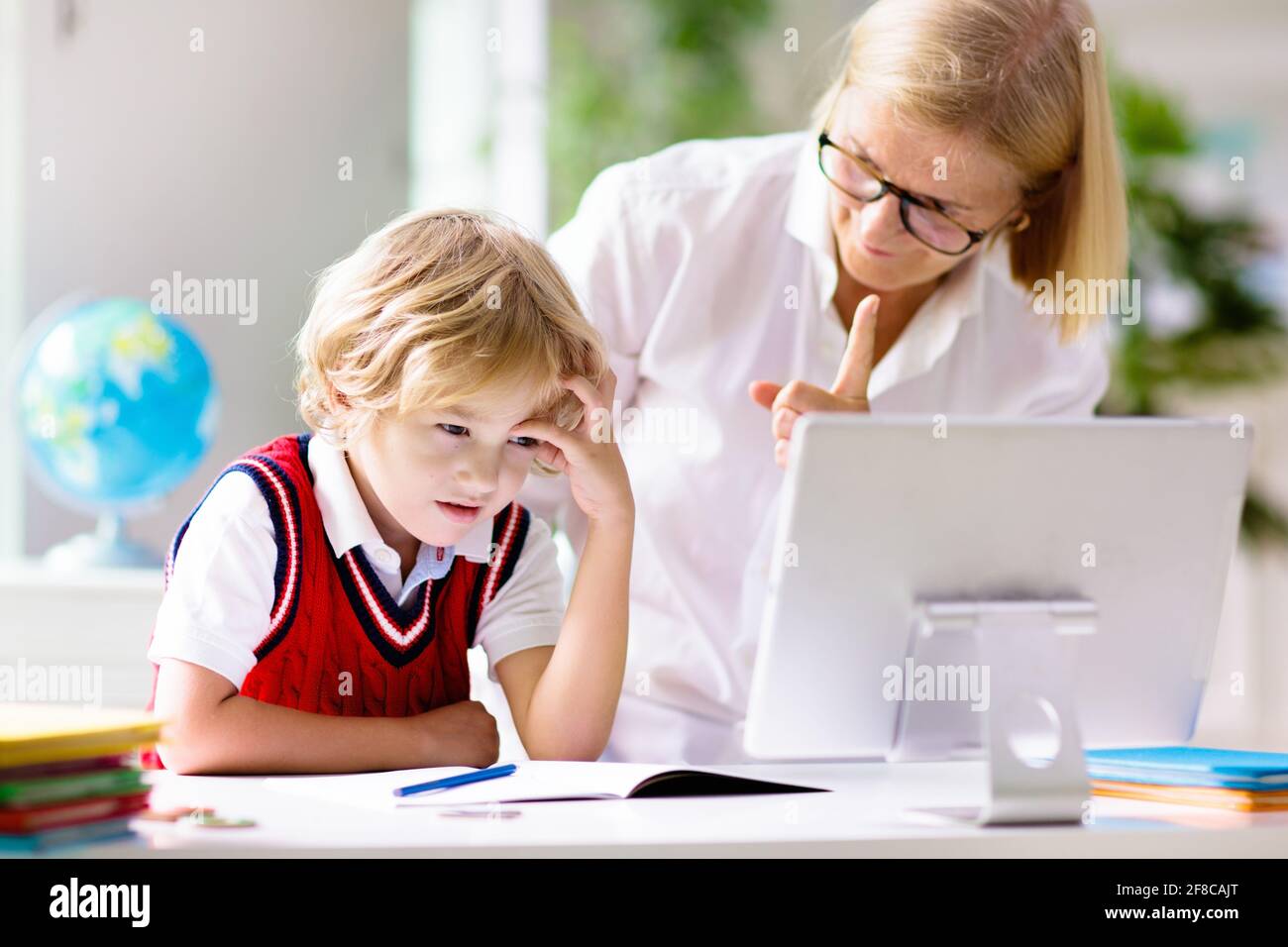 Online remote learning. School kids with computer having video ...