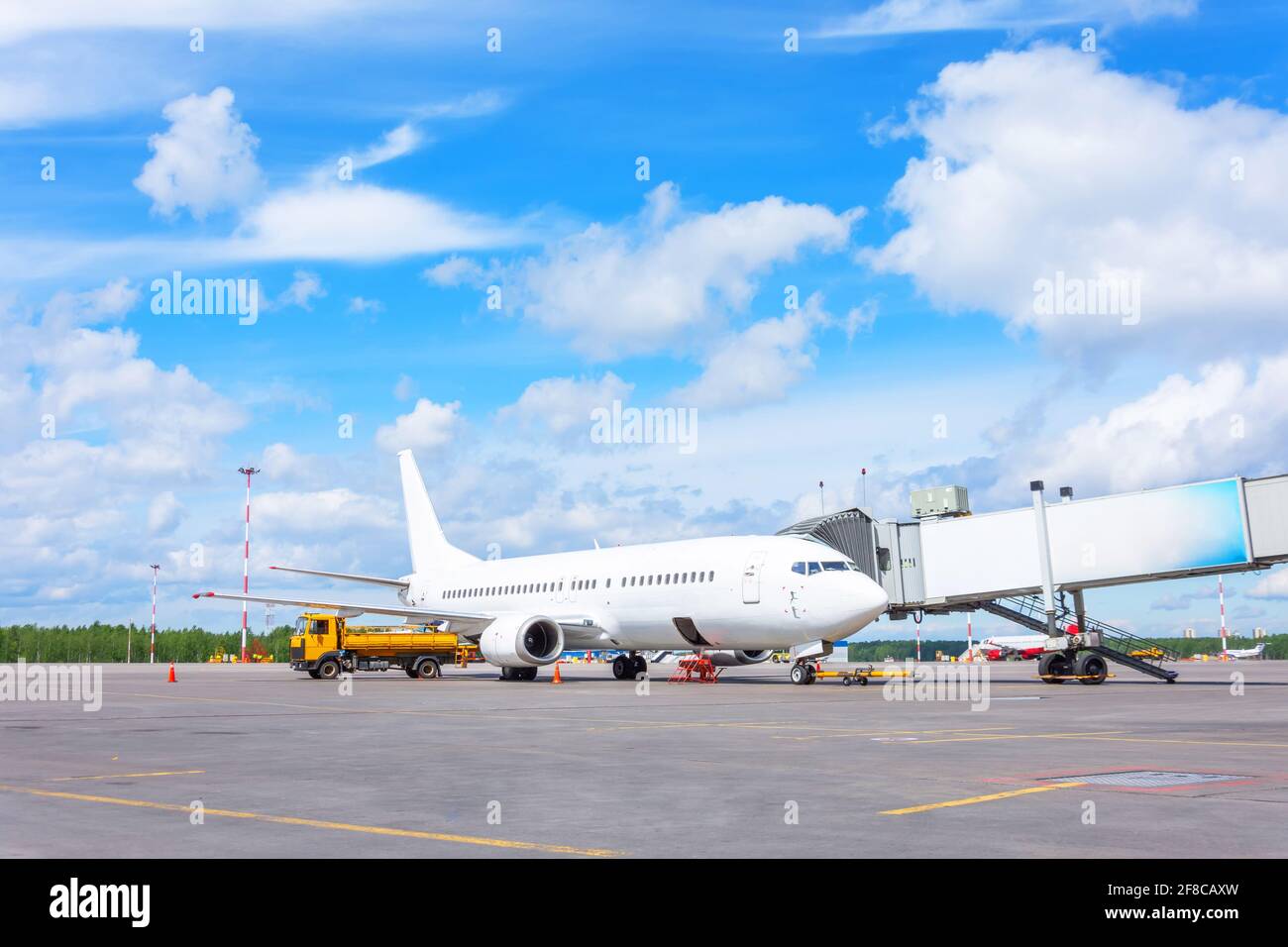 Passenger plane parked at the airport attached to the telescopic bridge ...