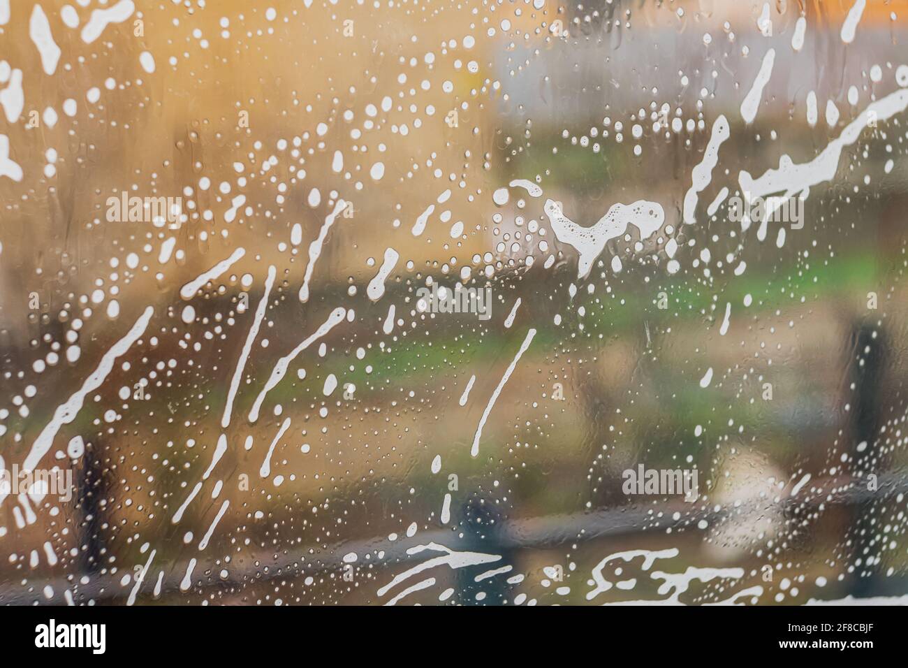 Streaks of water and soap foam on the window pane. The concept of ...
