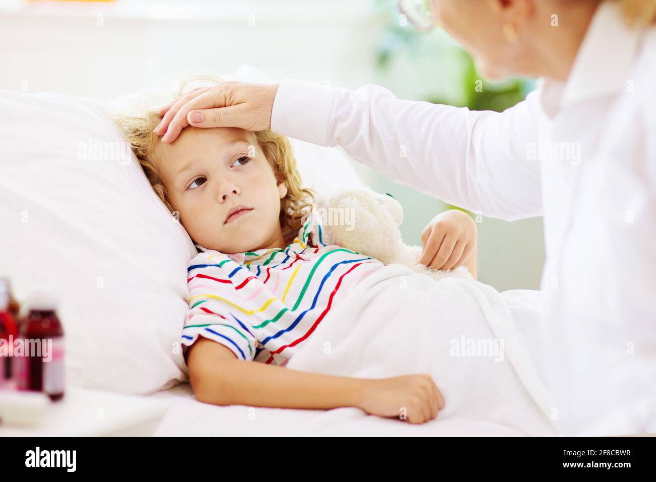 Sick little boy with medicine. Mother checking fever of ill child in ...