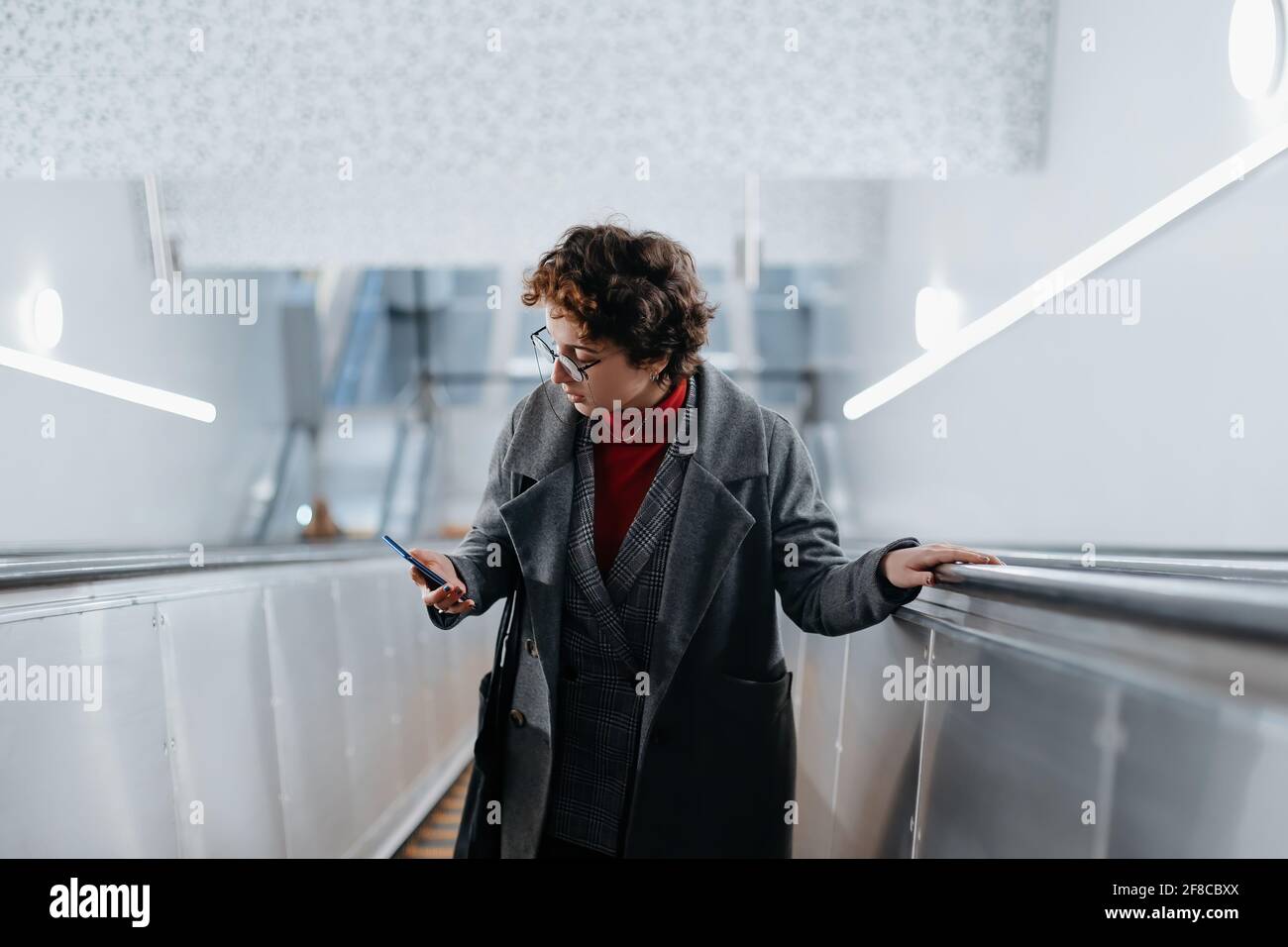 intelligent woman climbing the escalator in the subway Stock Photo - Alamy