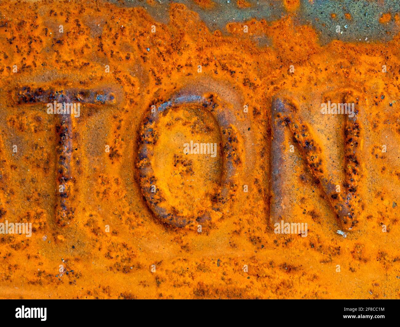 Rusty letters spelling TON on drain cover Stock Photo - Alamy
