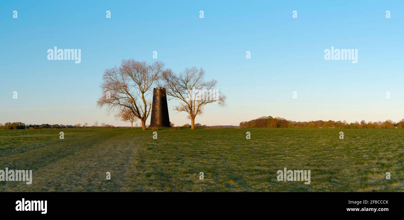 Black Mill, a local landmark, flanked by leafless trees under blue sky ...