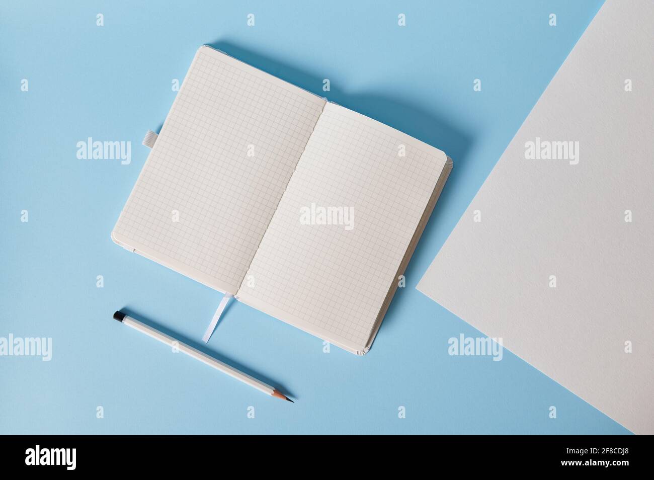 Flat lay composition of white writing tools on blue background. Space ...