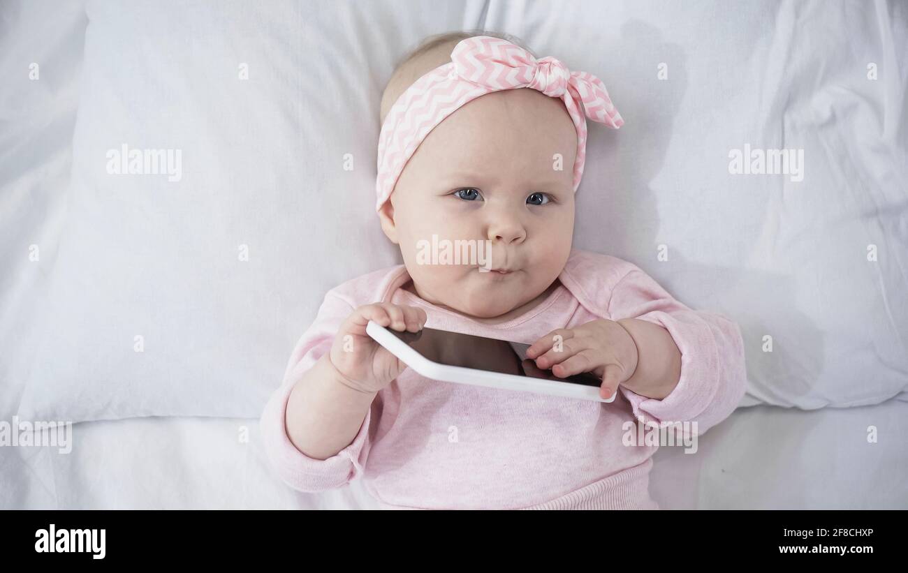 top view of infant holding smartphone with blank screen Stock Photo - Alamy