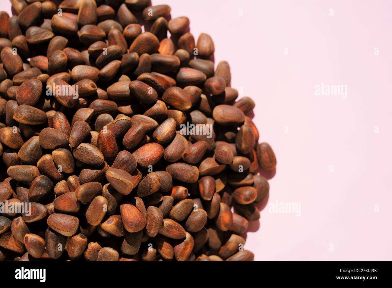 Pine nuts on a pink background. Nuts and seeds. cedar nuts. Organic and ...