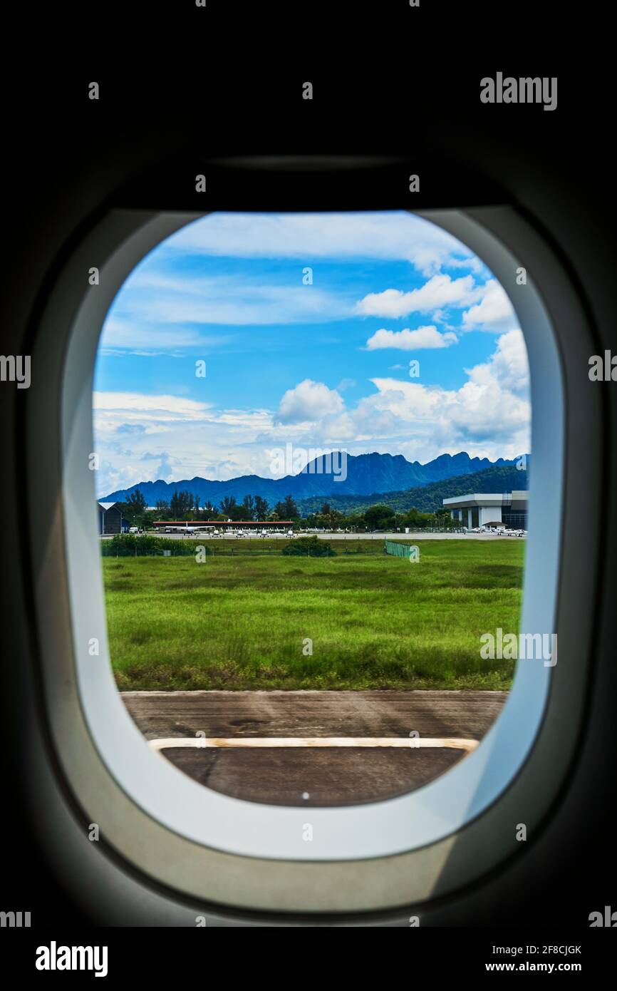 View from the window of an airplane on the runway of a tropical island ...