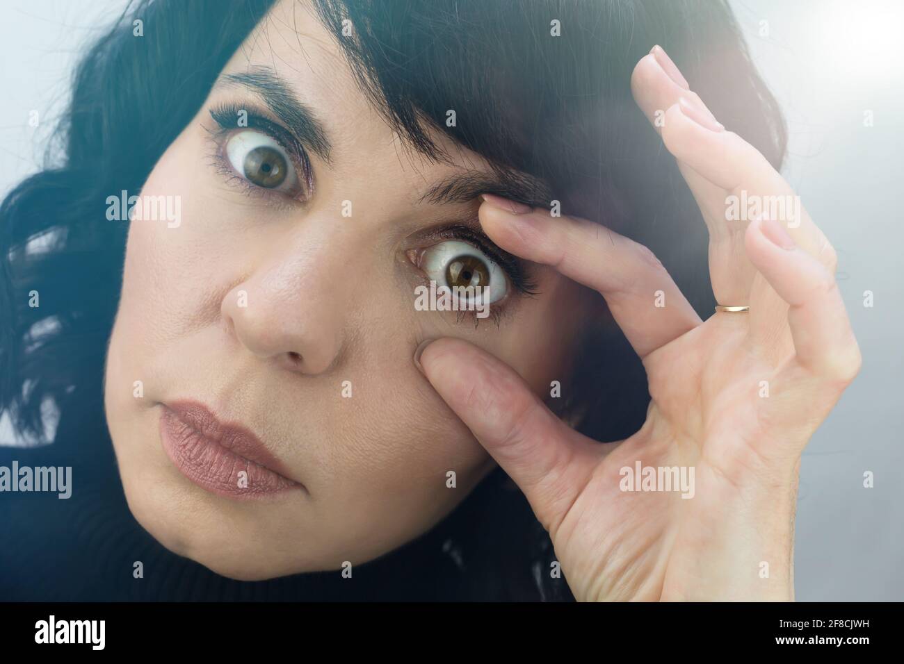 Woman opens her eyes with her fingers for inspection close-up Stock ...