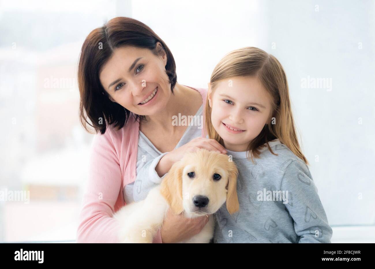 Sweet daughter and mother with lovely golden retriever dog Stock Photo ...