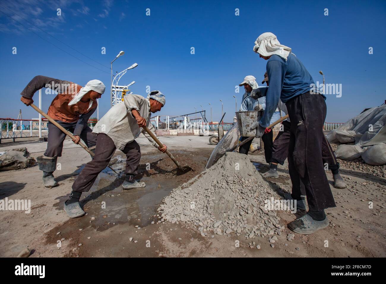 Kazakhstan, Shardara water storage dam. Group of Uzbek workers mixing ...