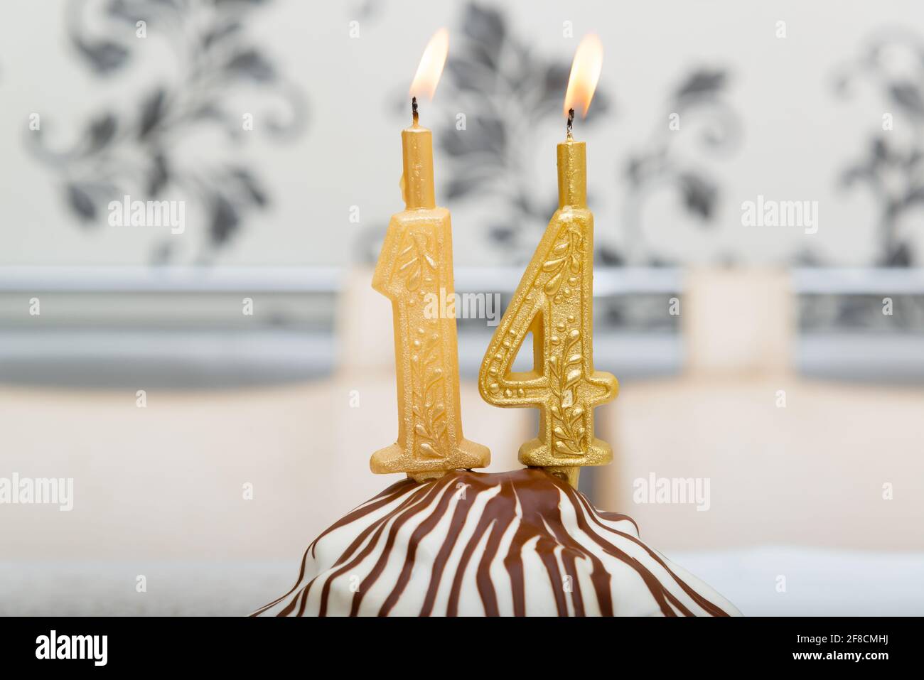 Lighted candles on the cake with the number 14 Stock Photo - Alamy