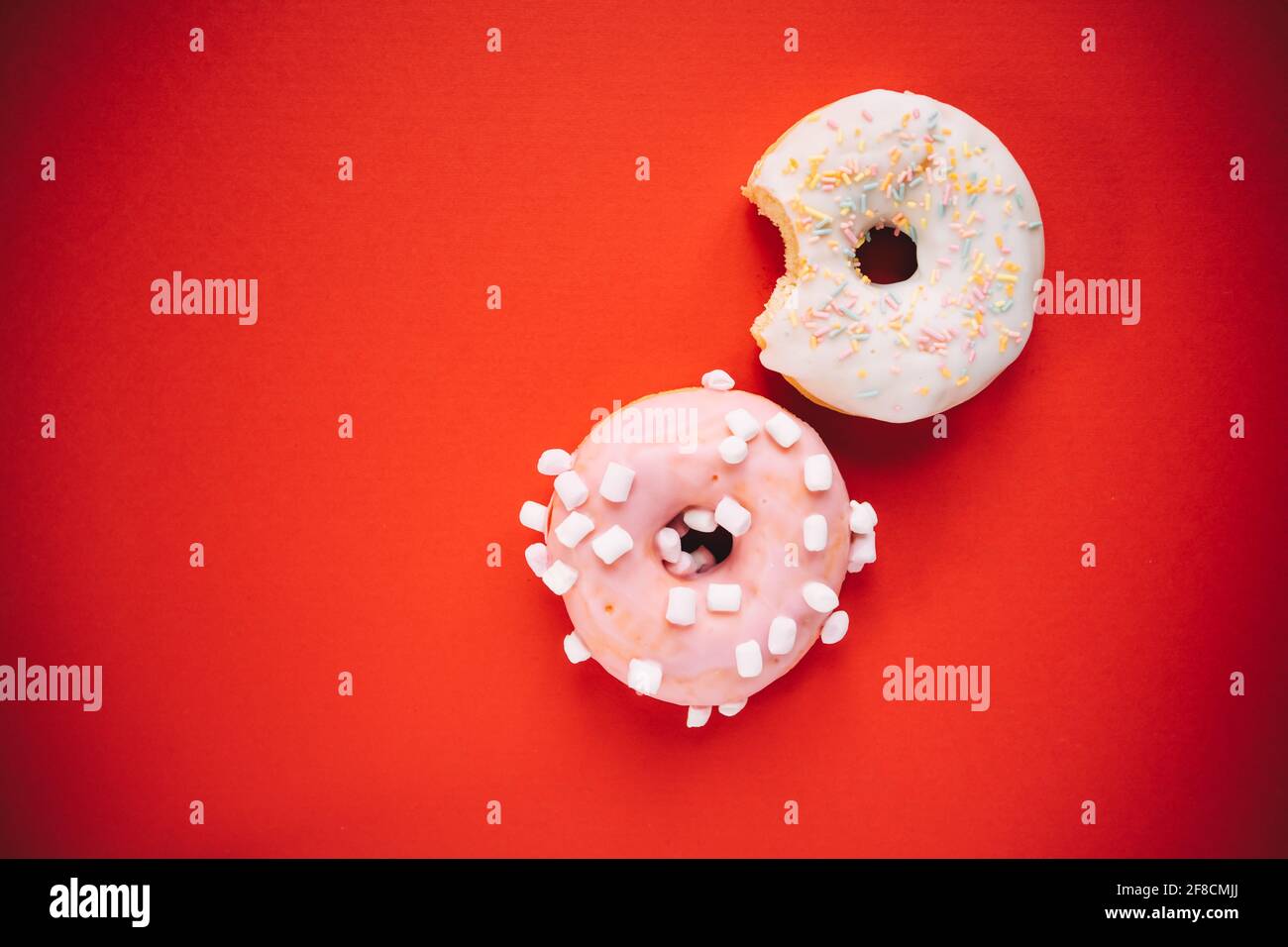 two donuts on a red background Stock Photo - Alamy