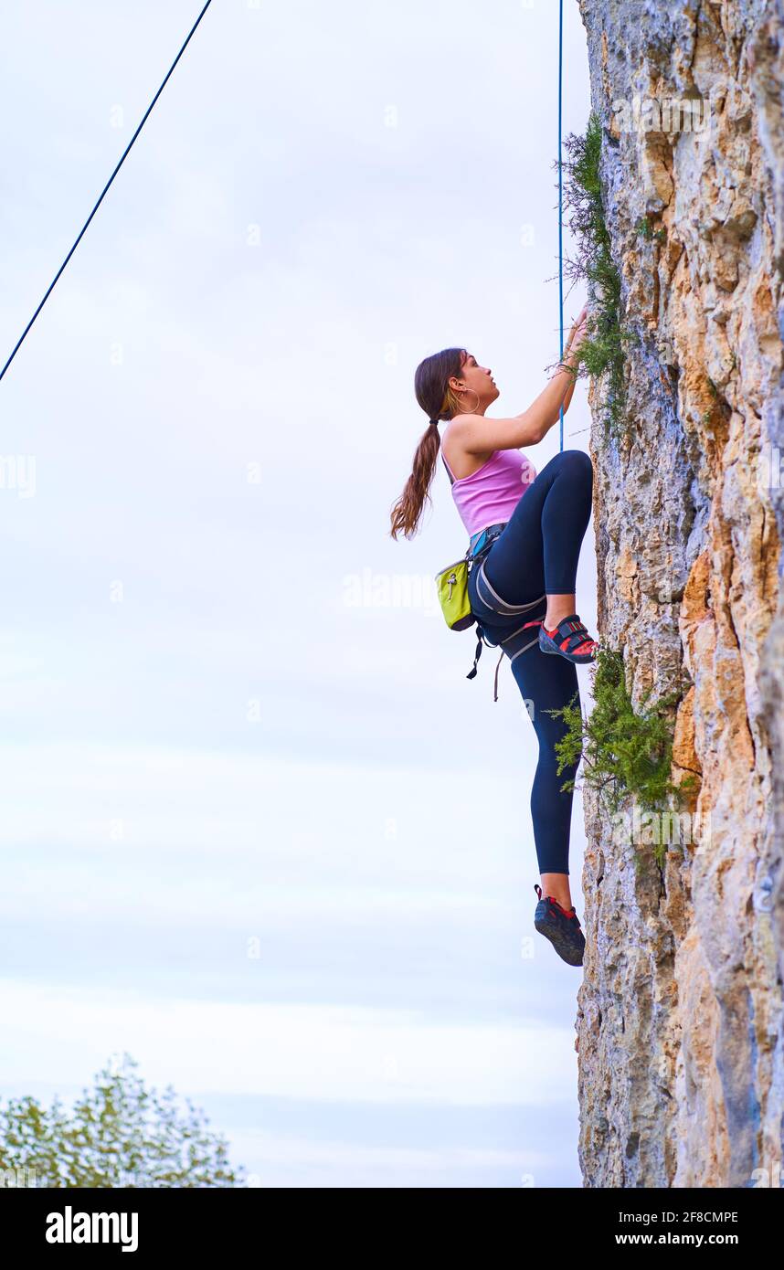 Vertical profile photo of a young woman rock climbing outdoors Stock ...