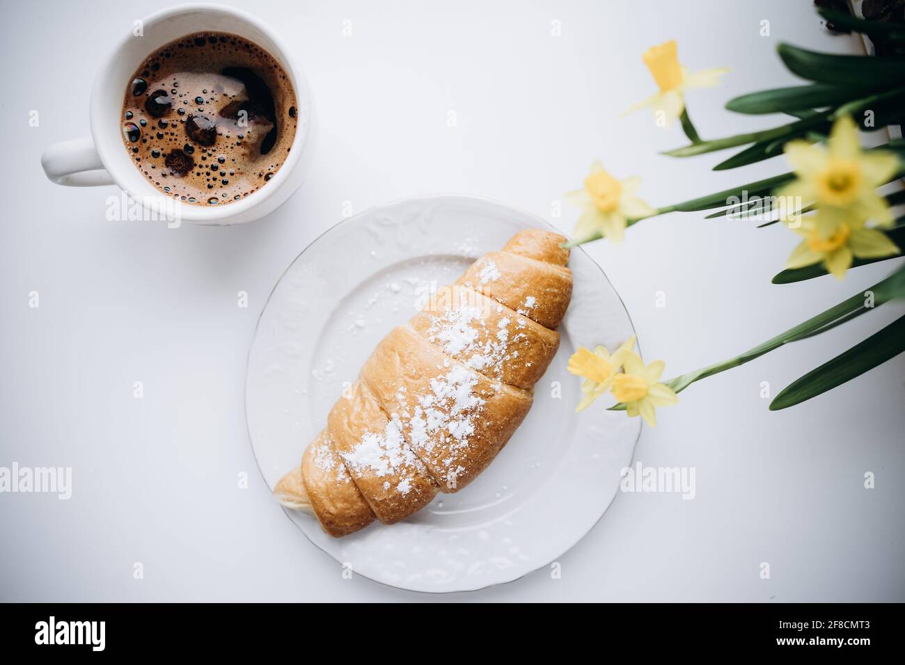 croissant, coffee and yellow flowers Stock Photo - Alamy