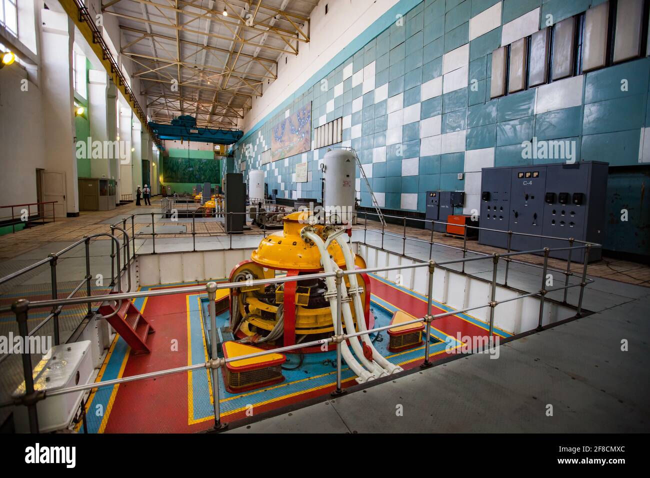 Machine room of Shardara hydroelectric plant. Yellow generator machine ...