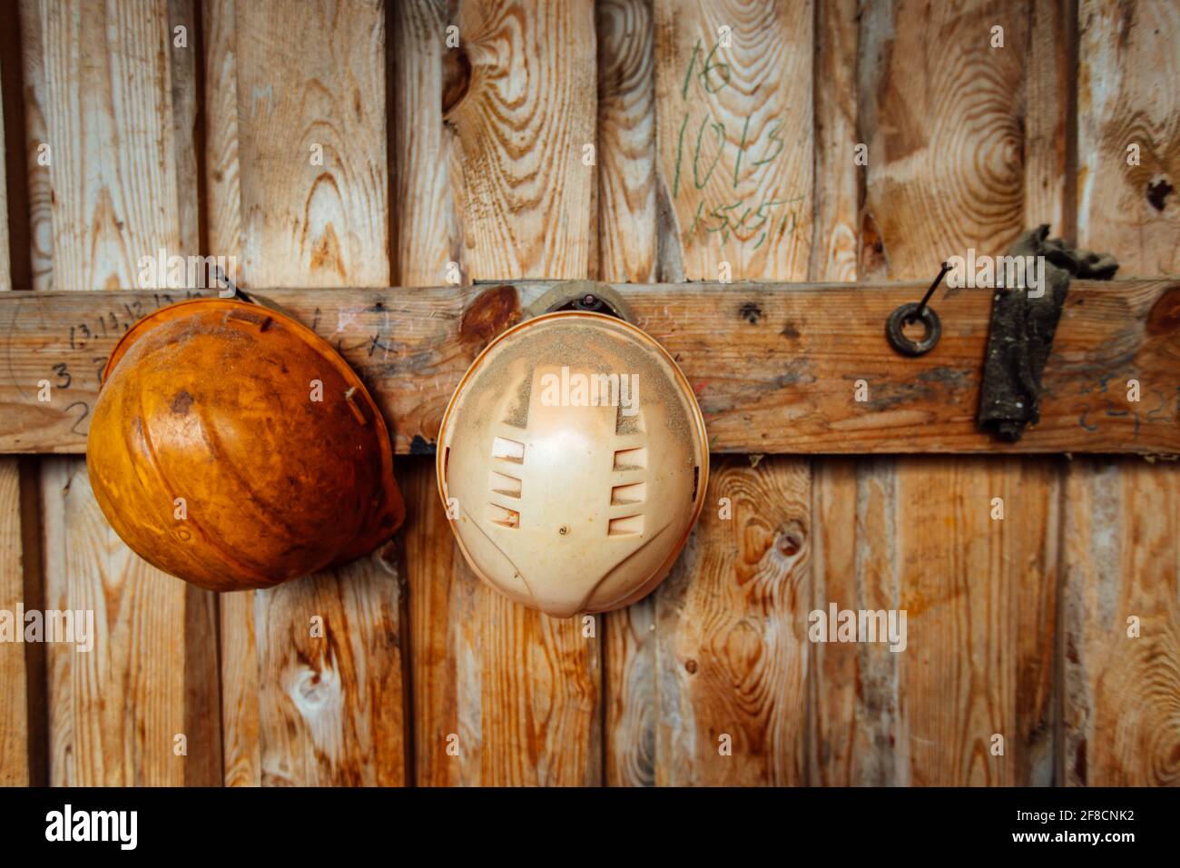 construction helmets hang on a hook on the wall. head protection in ...