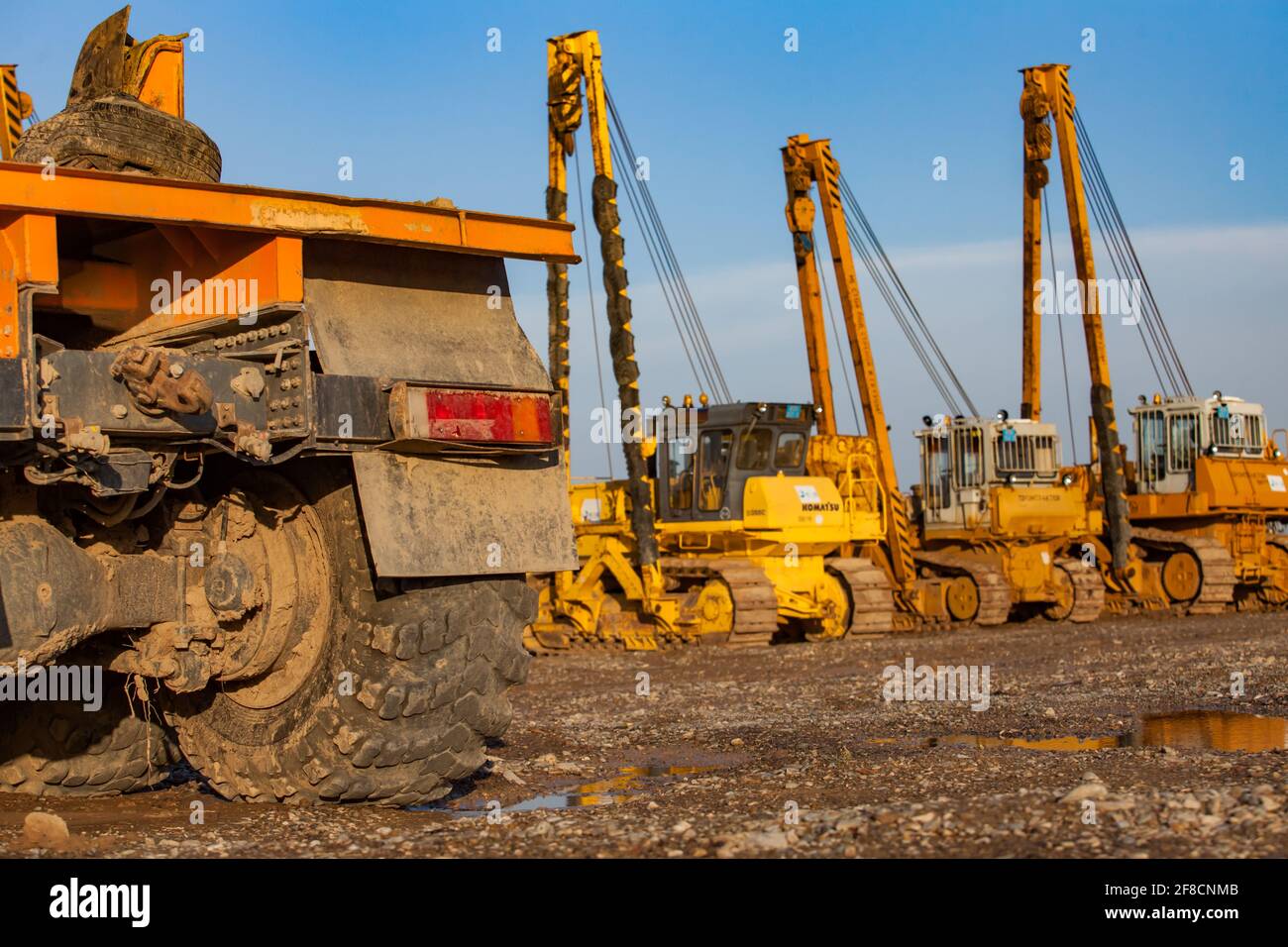 Yellow construction crawler piling machines (right) on parking. Left ...