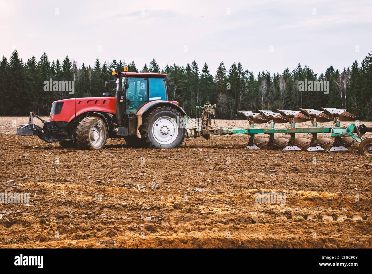 Tractor plowing fields - preparing land for sowing Stock Photo - Alamy