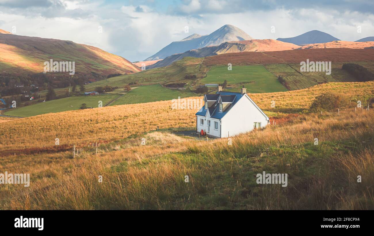 A lone traditional Scottish Highlands white croft house cottage in a ...