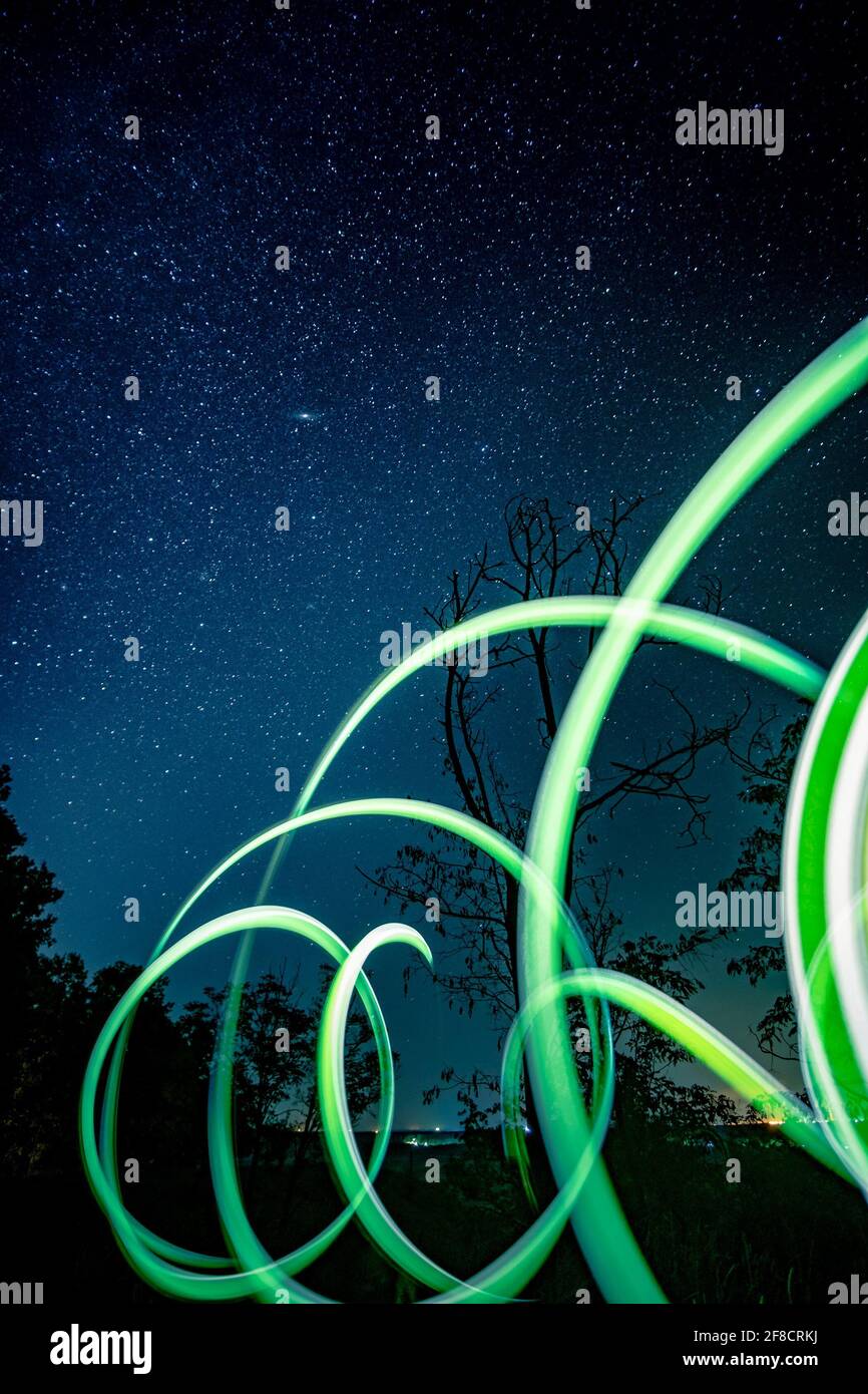 Trace of neon light on starry sky background Stock Photo - Alamy