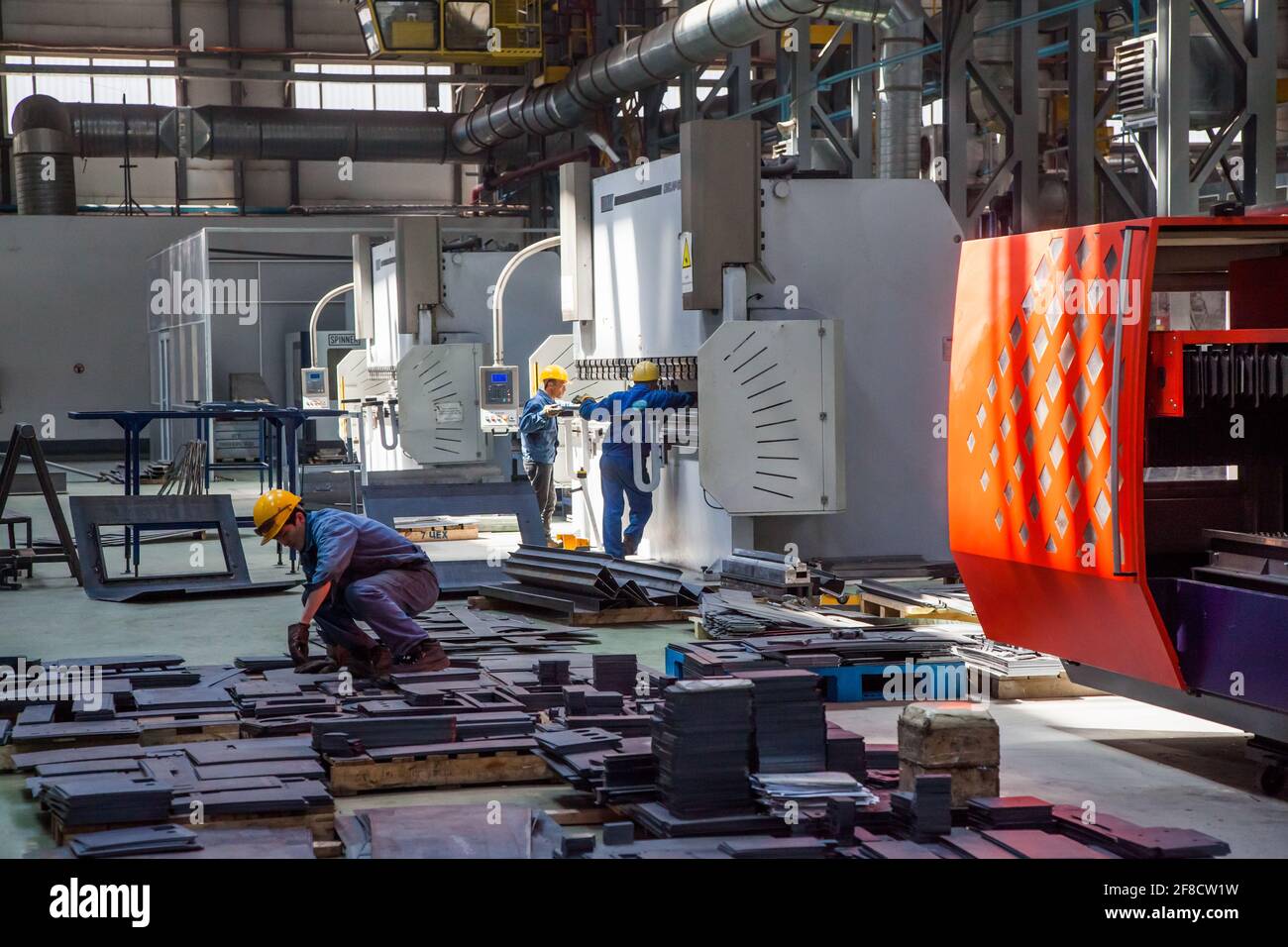 Locomotive-building plant. Workers adjusting CNC machine Stock Photo ...