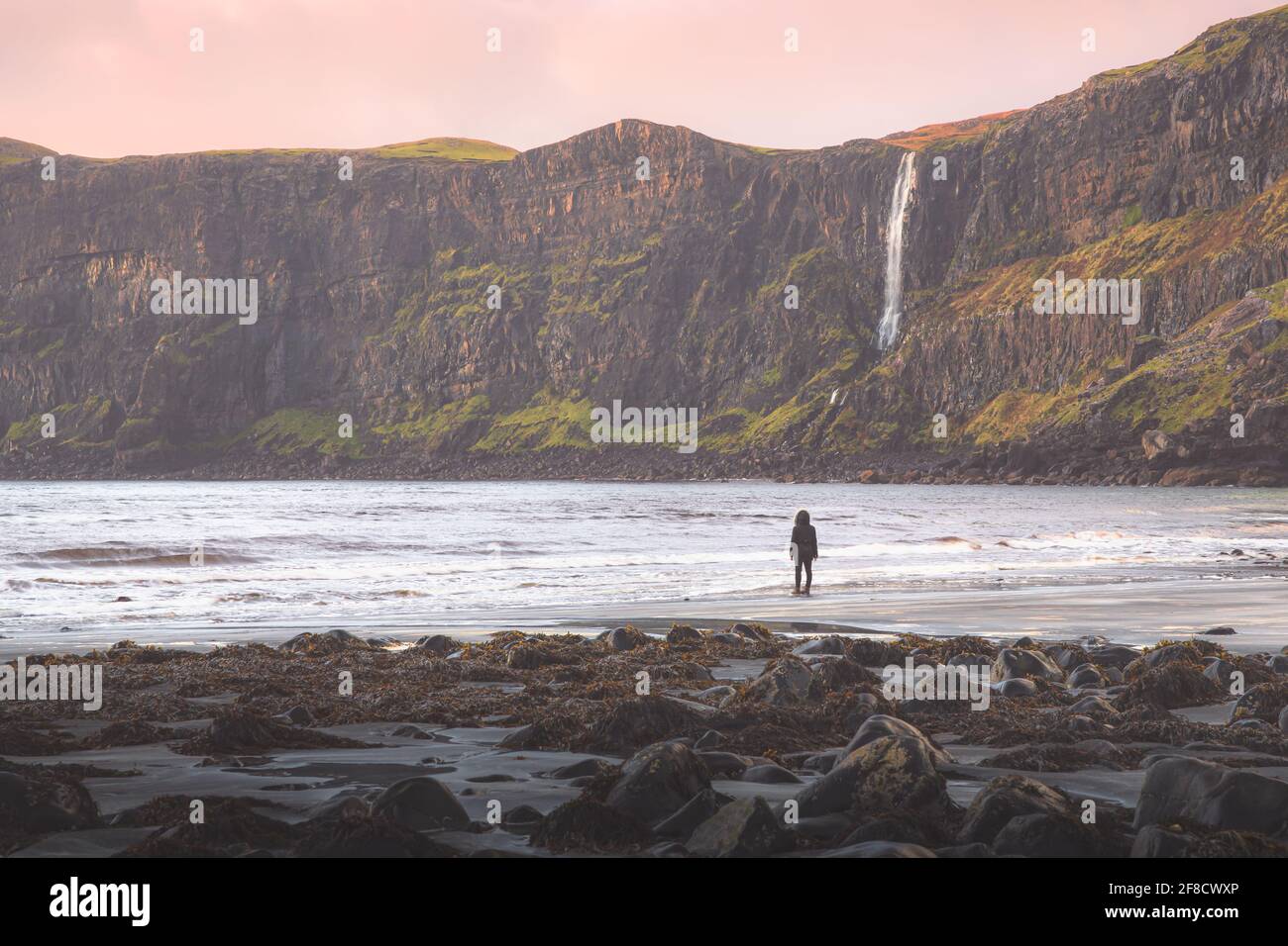 A female tourist alone in nature visits the coastal landscape at ...