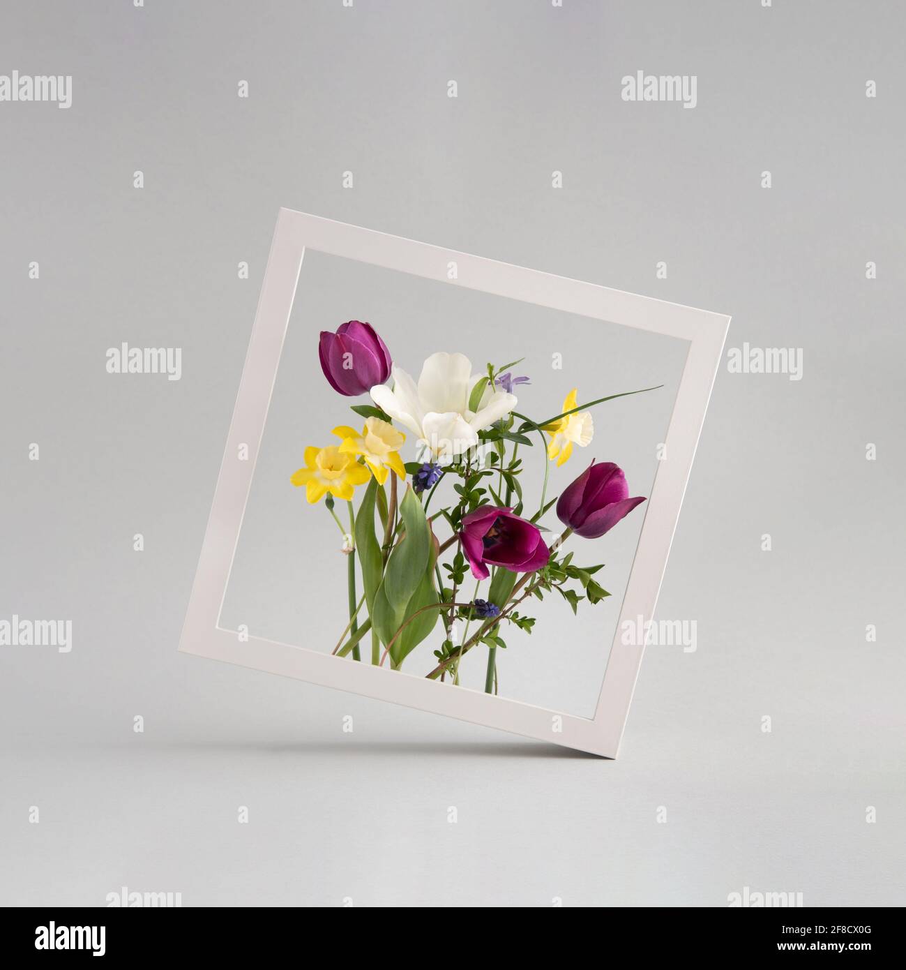 Colorful flower bouquet arranged inside square white photo frame ...