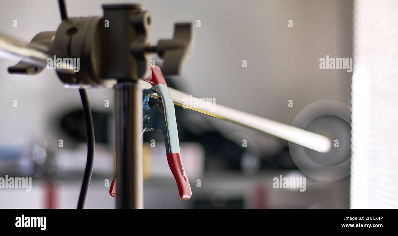 Close-up of red clamp on C-stand inside a photo studio Stock Photo - Alamy