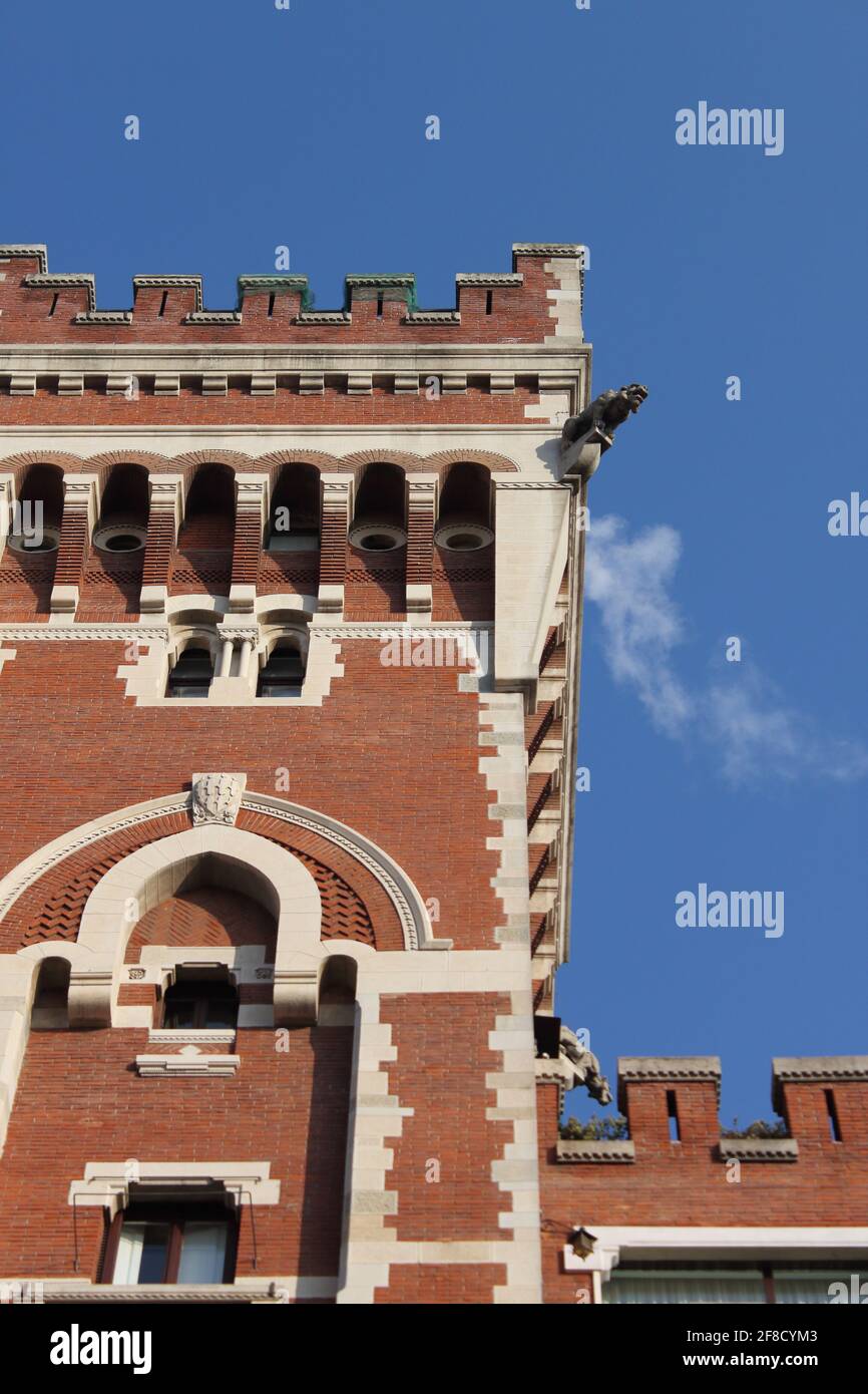 decorative gargoyle on the facade of a stately red brick building ...