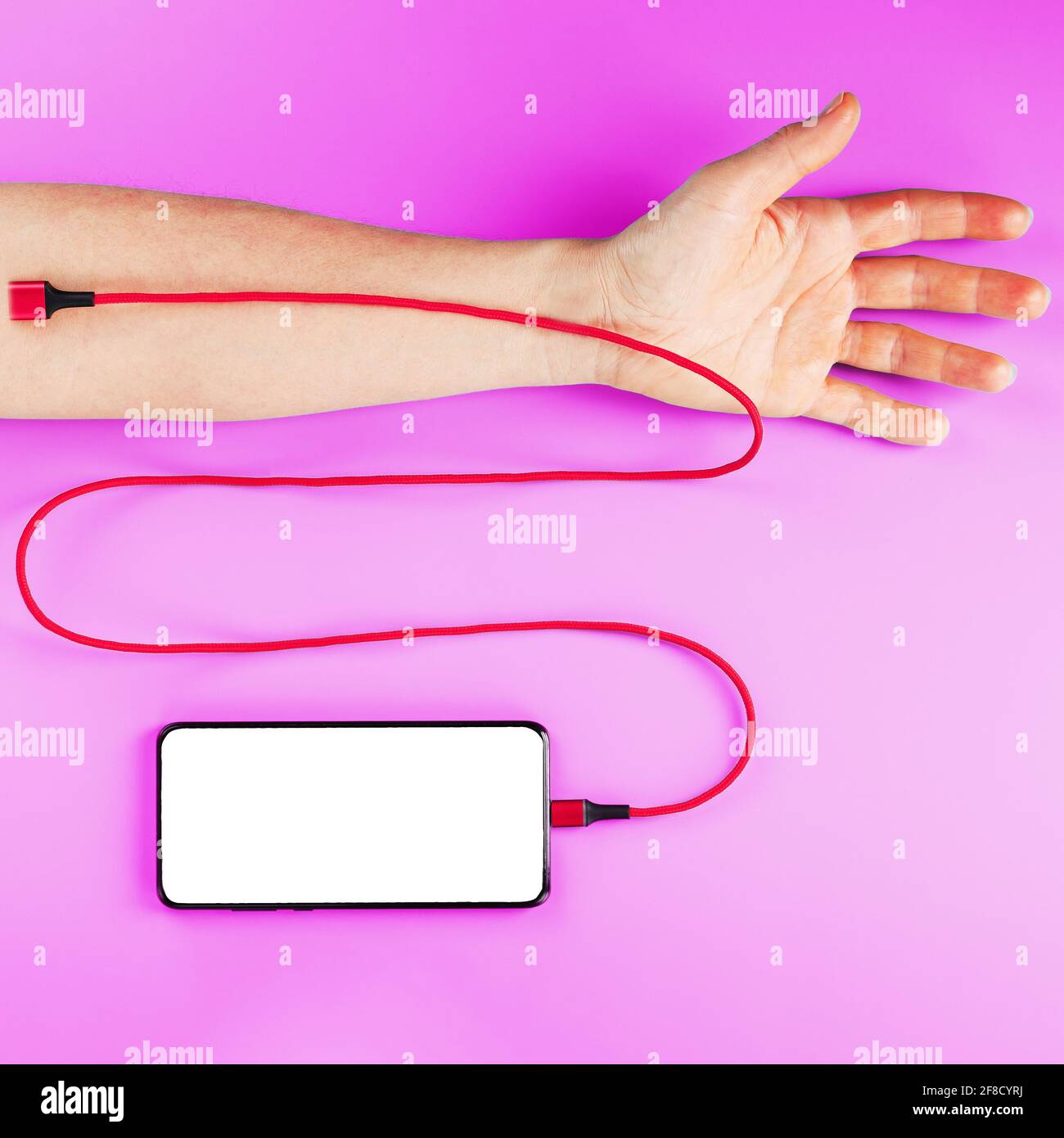 A smartphone with a large white screen is connected via a red USB cord ...