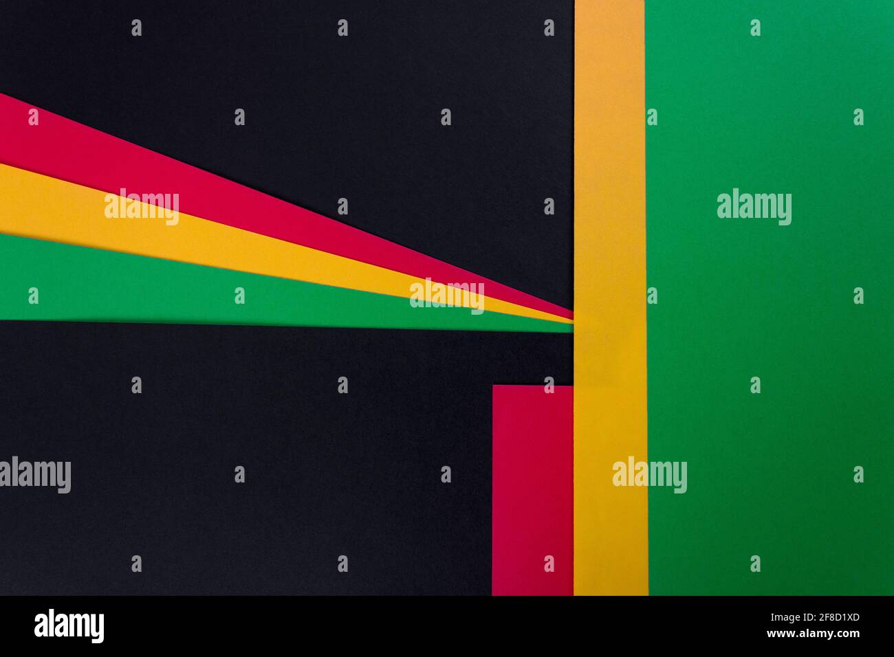 Red, yellow and green color paper on the black background. Black ...