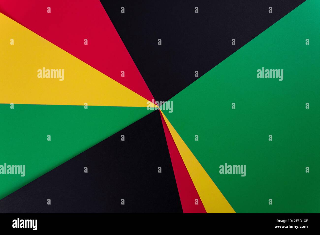 Red, yellow and green color paper on the black background. Black ...