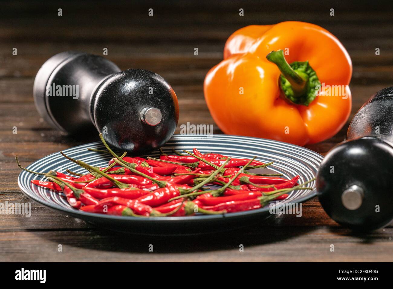 Fresh Red Birds Eye Chilli in a plate on a wooden table with a BLACK ...