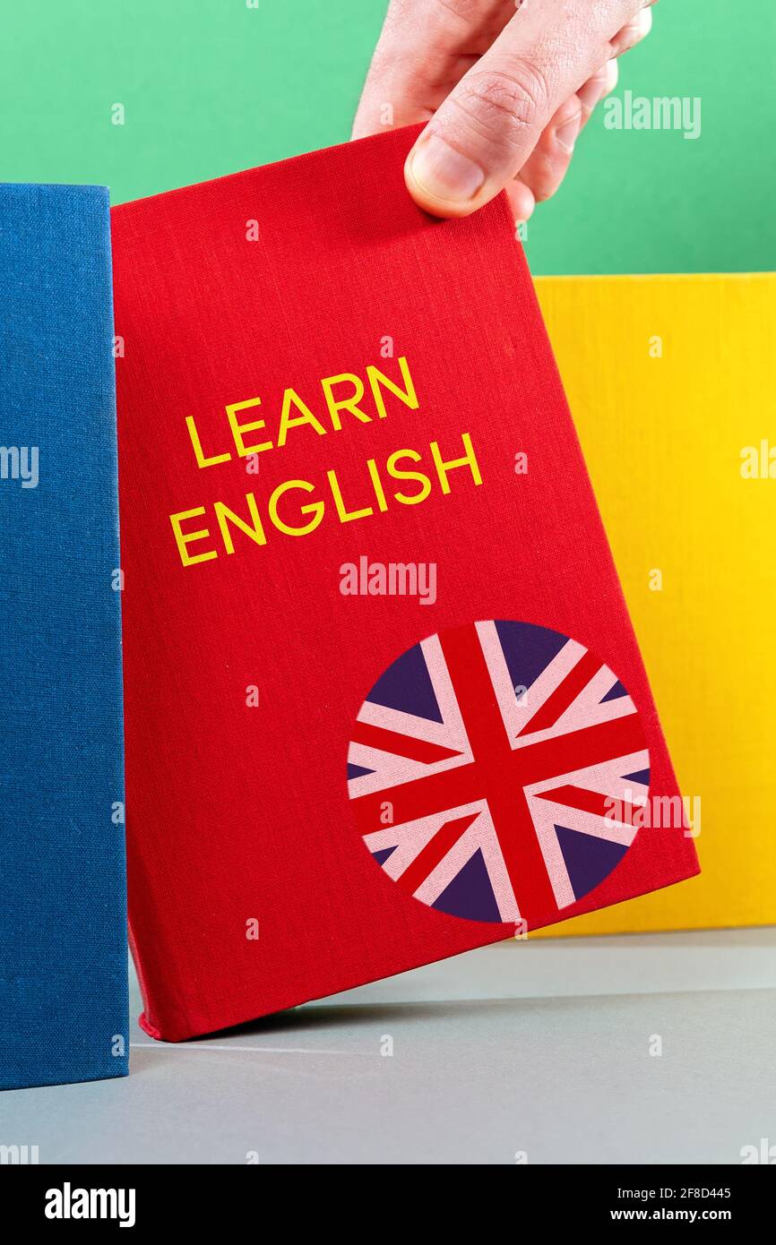 A man's hand holds an English textbook. Close-up of hands and book ...