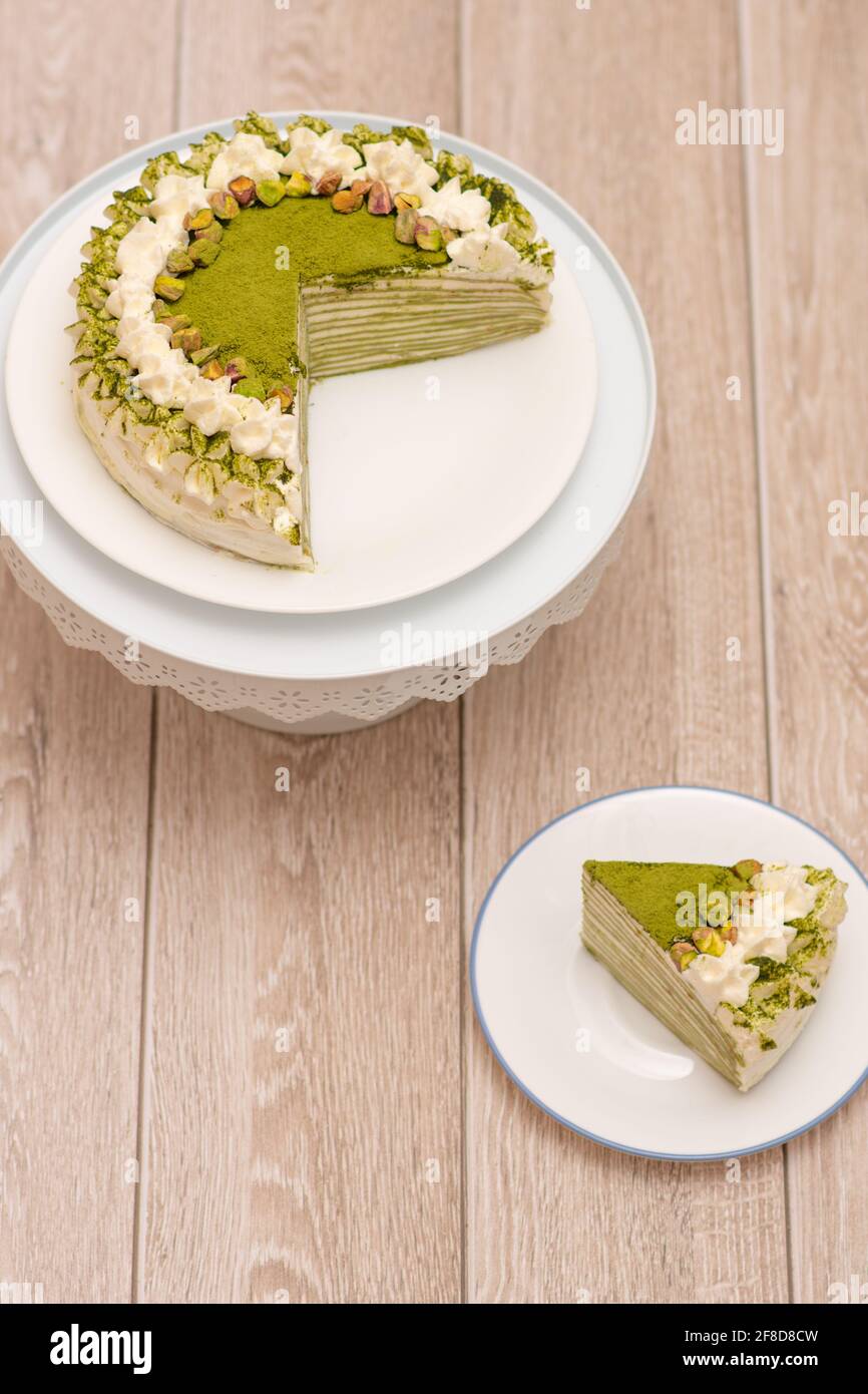 Matcha Mille Crepe Cake Presented On A Cake Holder With A Slice On A ...